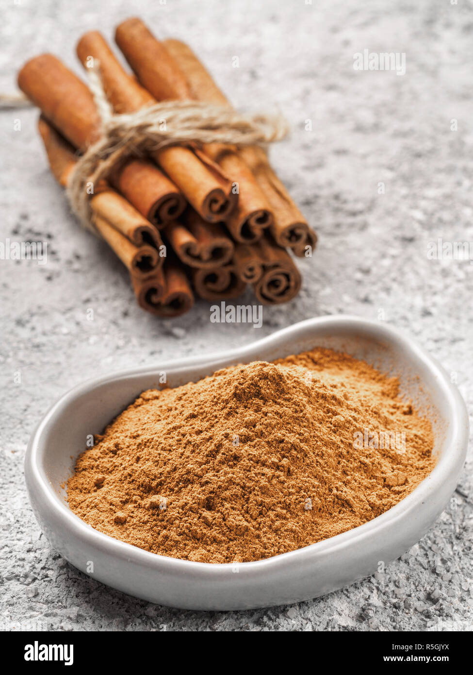 Ground cinnamon on gray background Stock Photo - Alamy