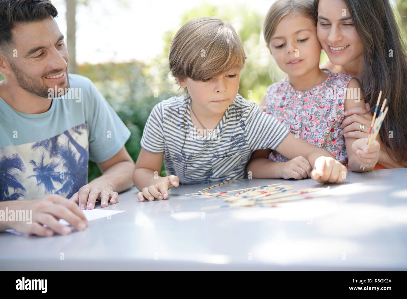 Happy family enjoying playing game together Stock Photo - Alamy