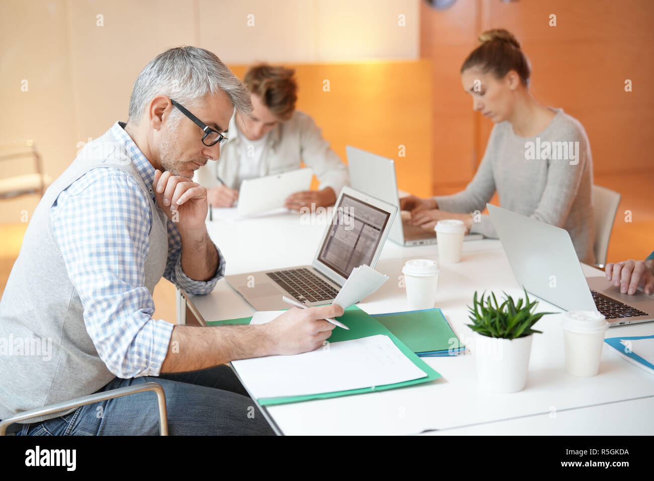 Teacher meeting around table with students Stock Photo - Alamy