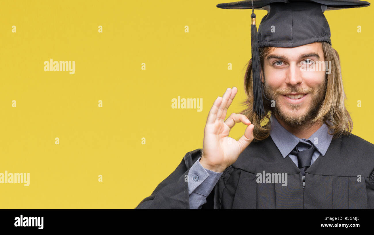 Young handsome graduated man with long hair over isolated background ...