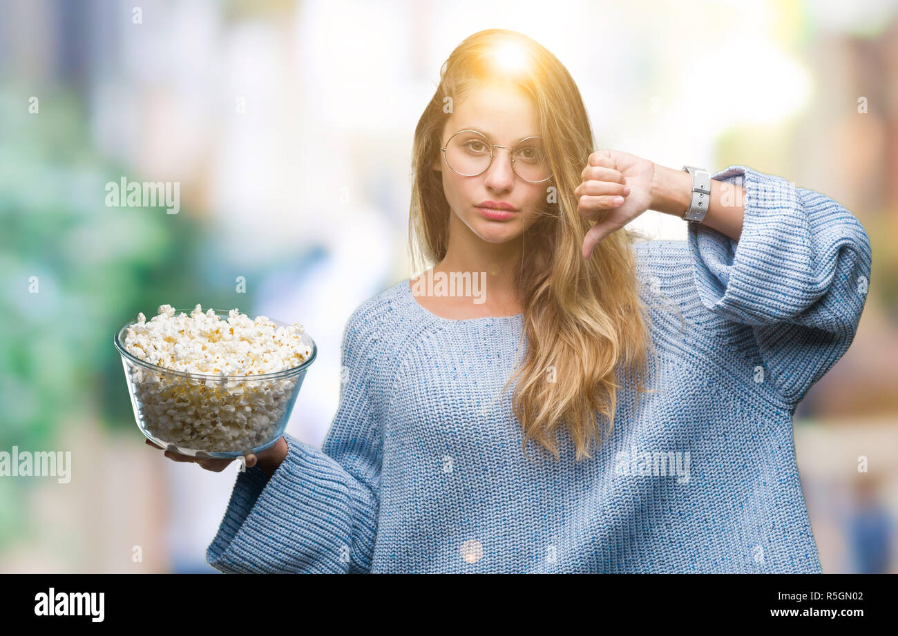 Young beautiful blonde woman eating popcorn over isolated background ...