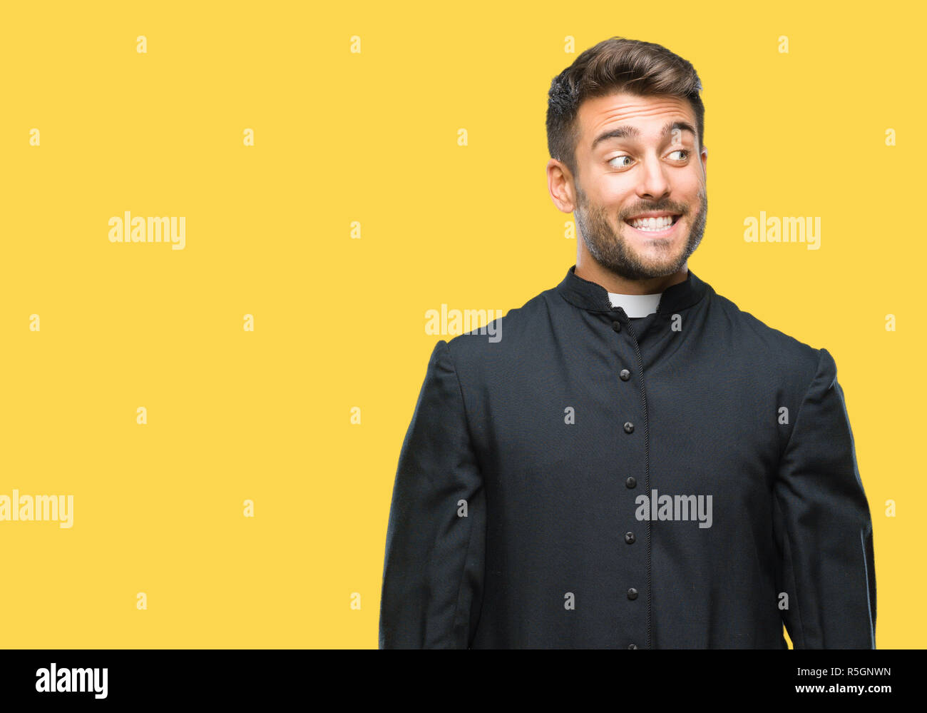 Young catholic christian priest man over isolated background smiling ...