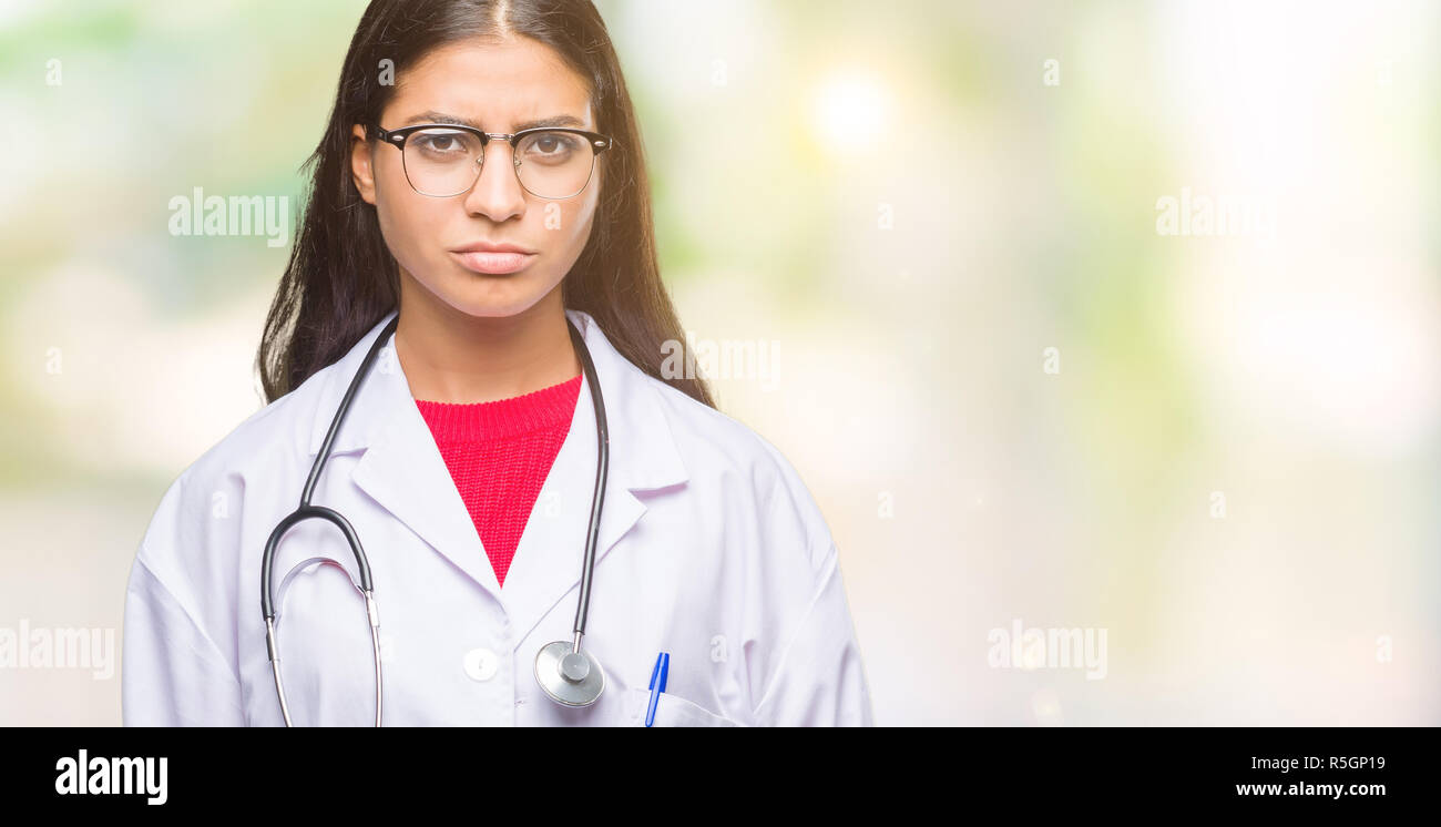 Young arab doctor woman over isolated background skeptic and nervous ...