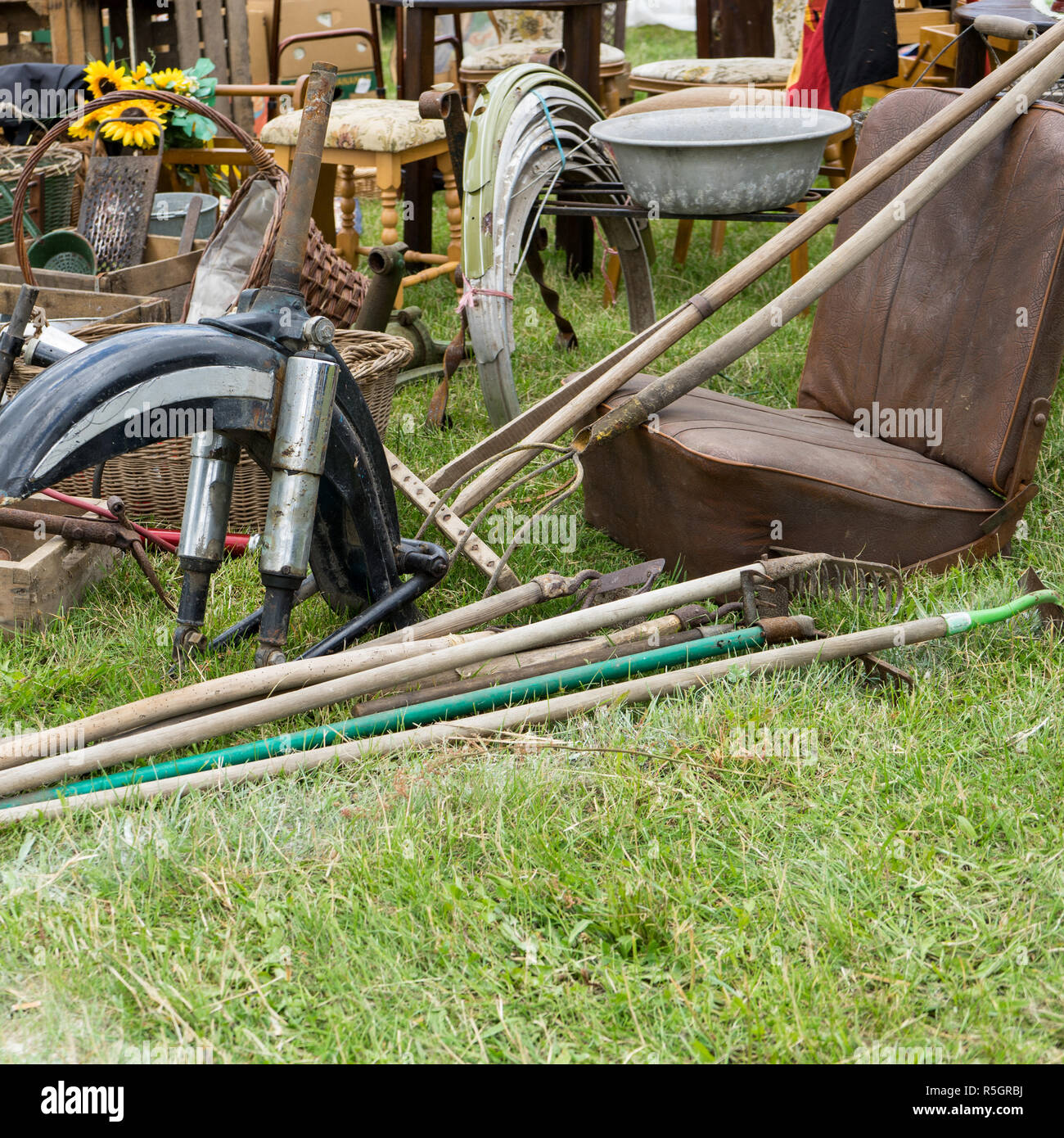 Flea market stall with garden tools, furniture and dishes Stock Photo ...