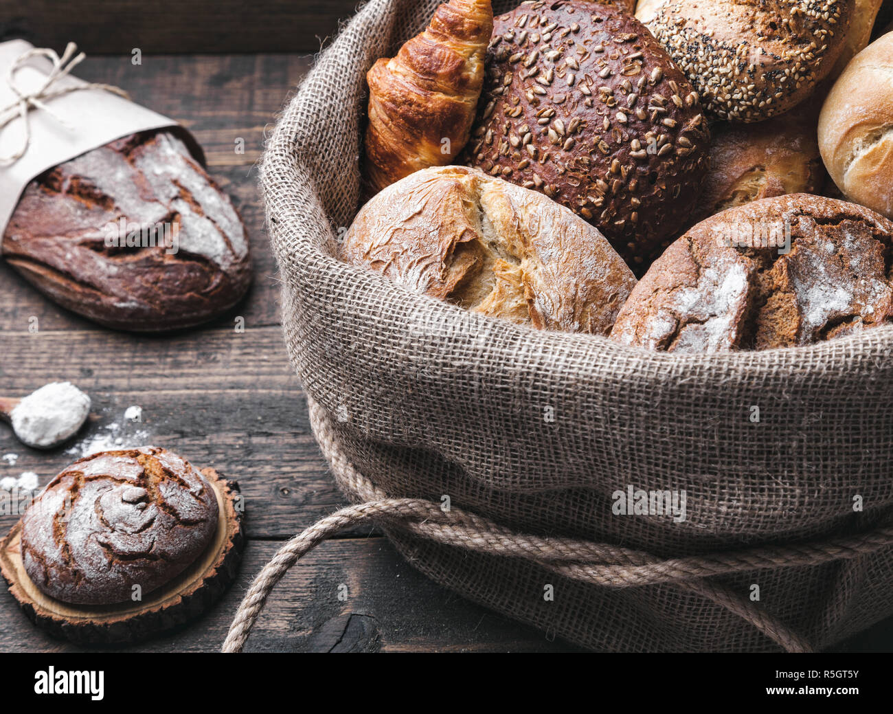 Delicious fresh bread inside a sack on wooden background Stock Photo ...