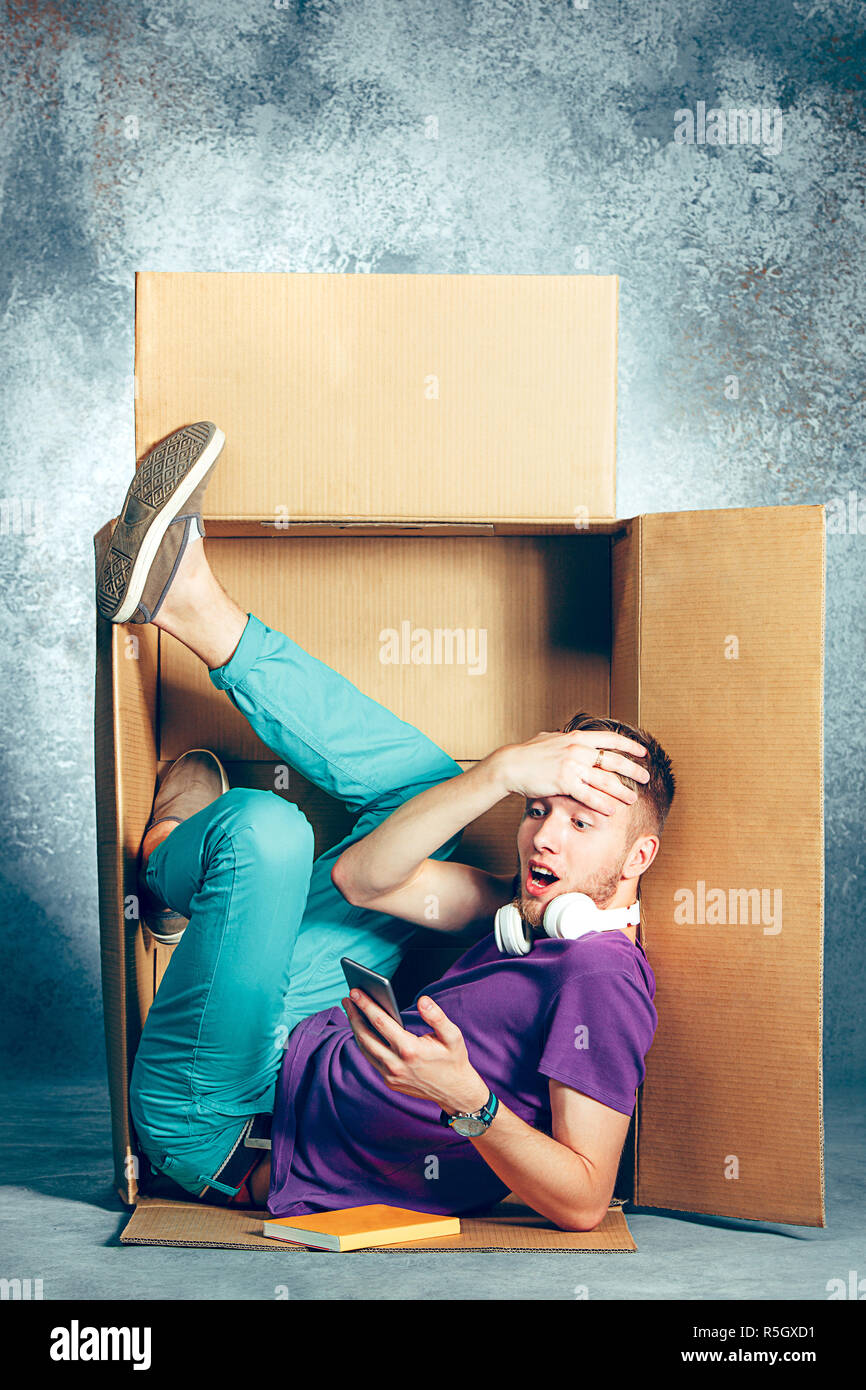 Introvert concept. Man sitting inside box and working with phone Stock ...