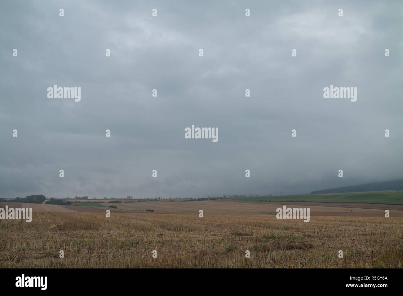 rain clouds over harvested field Stock Photo - Alamy