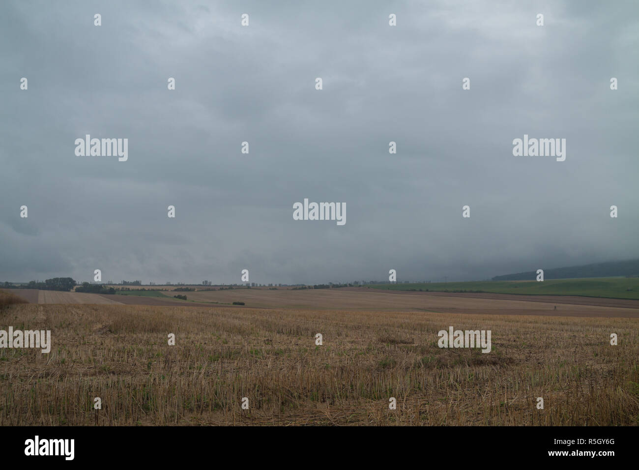 rain clouds over harvested field Stock Photo - Alamy