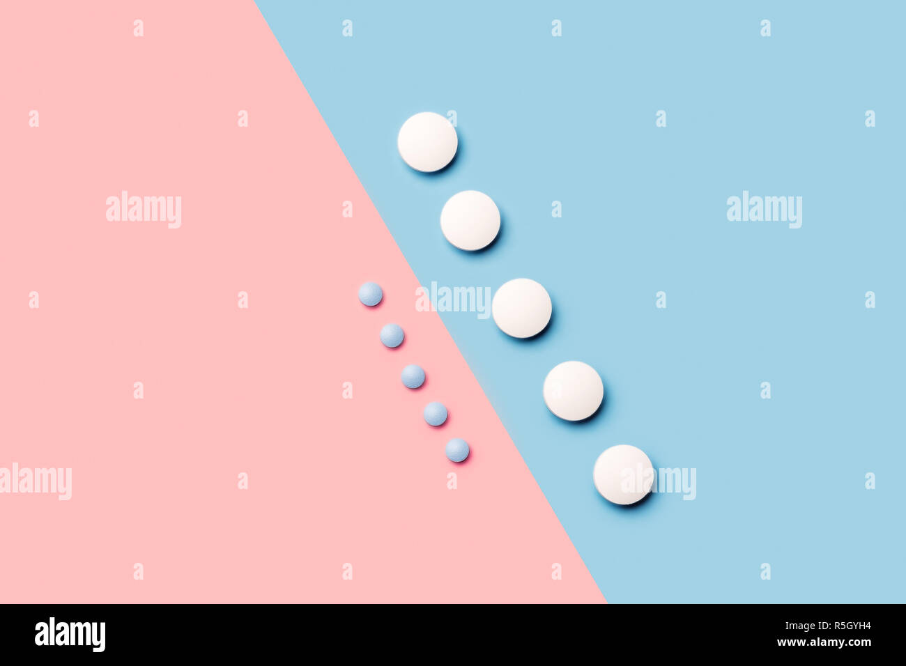 A line of large white round pills and small round blue pills arranged ...