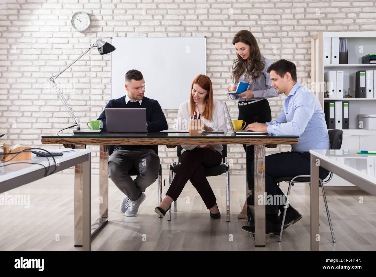 Happy Business People Doing Work At Workplace Stock Photo - Alamy