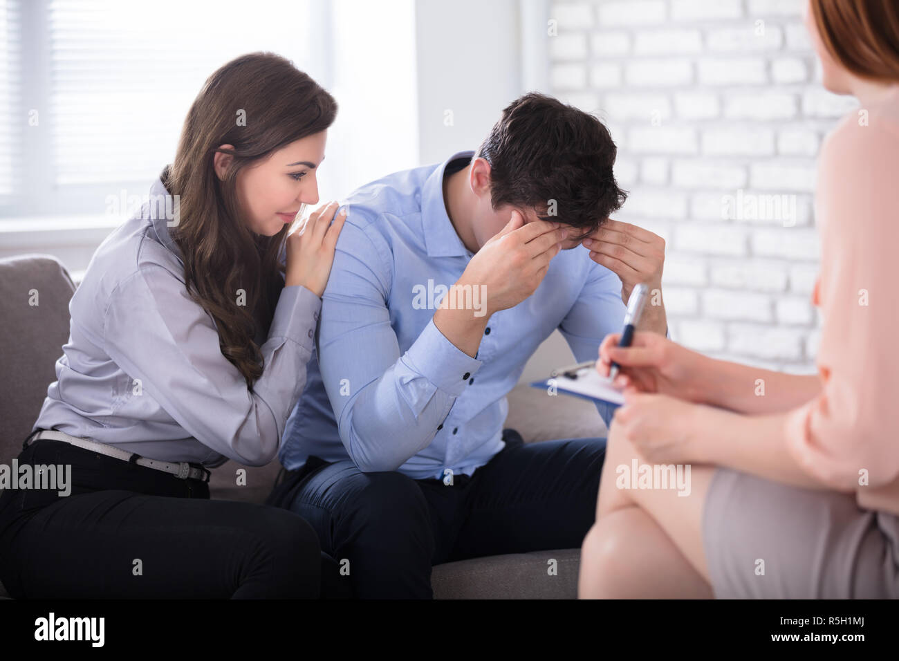 Woman Consoling His Husband Sitting With Psychologist Stock Photo - Alamy