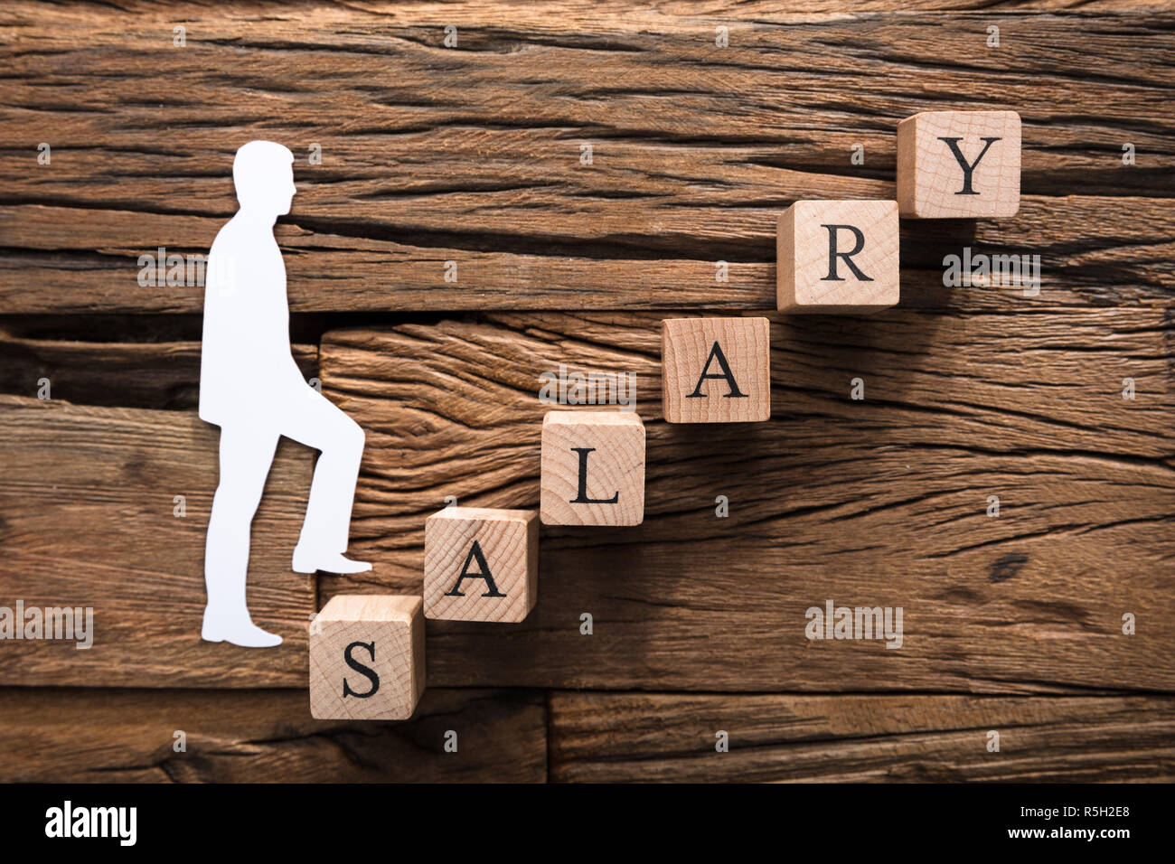 Paper Businessman Climbing Salary Block Ladder On Wood Stock Photo - Alamy