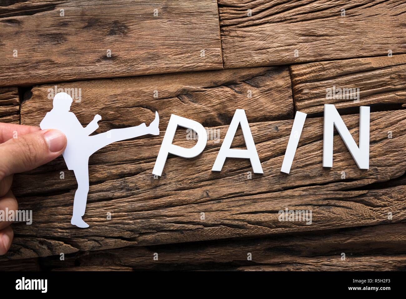 Hand Holding Paper Businessman Kicking Word Pain Stock Photo - Alamy