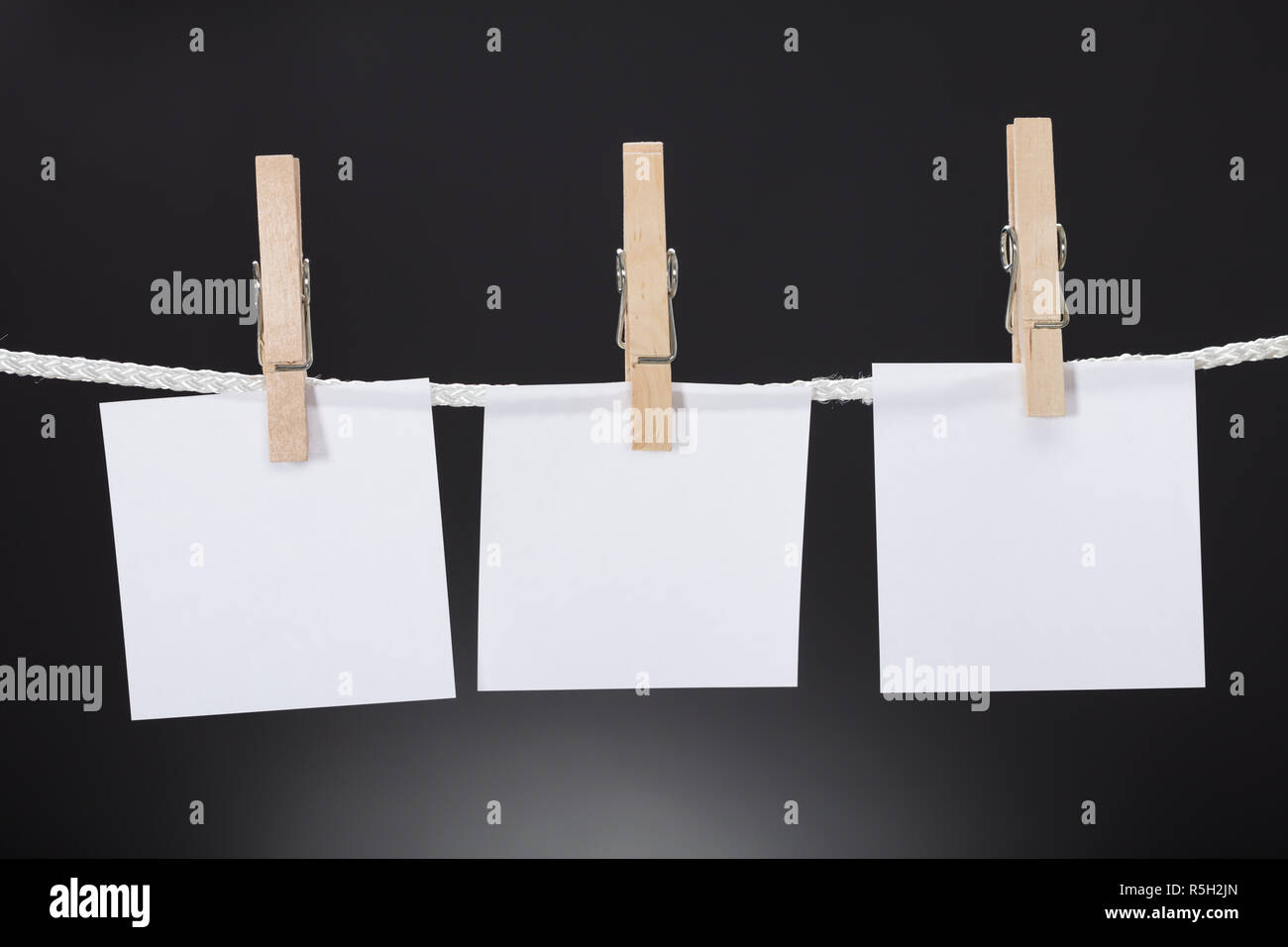 White Paper Cards Hanging On Rope Attached With Clothespins Stock Photo ...