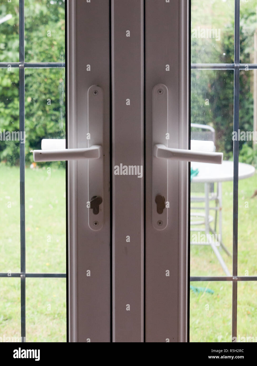two locked backdoor handles up close garden Stock Photo - Alamy
