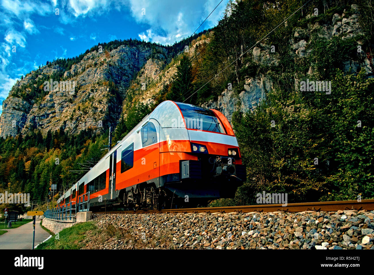 Red blue train in motion in Austrian alps mountains. High speed ...