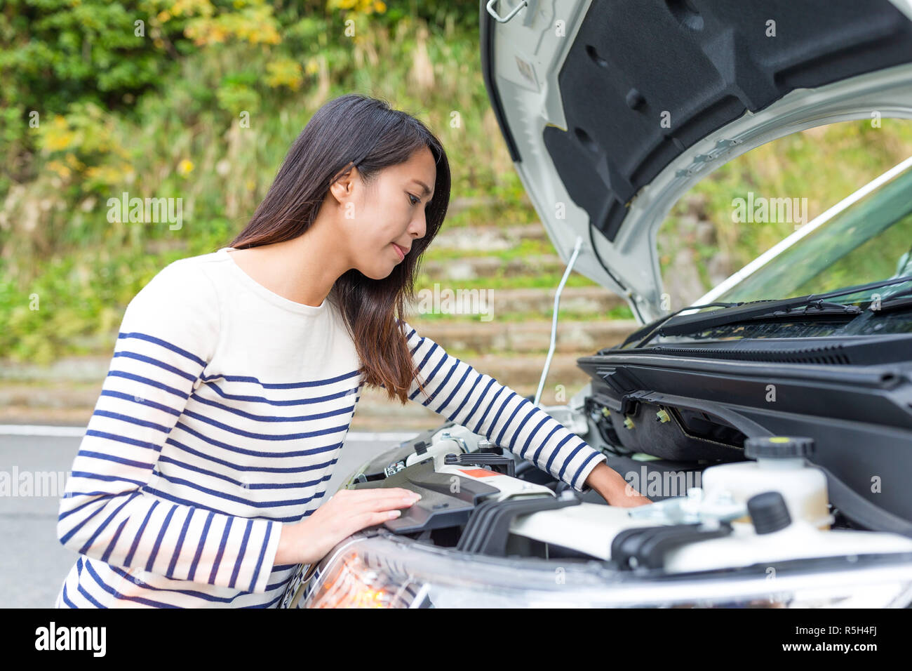 Woman trying to repair a car engine Stock Photo - Alamy