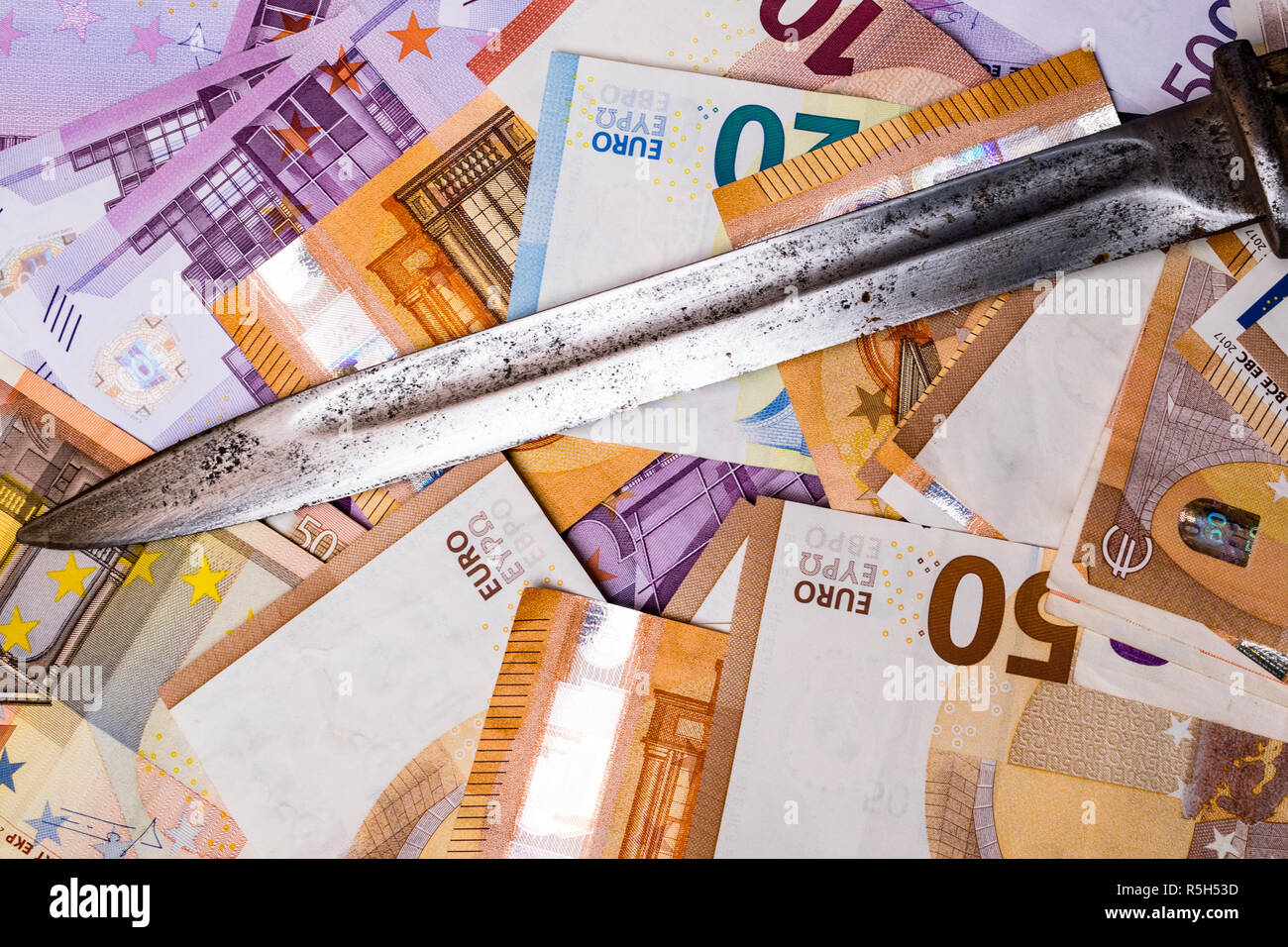 A crime scene - a knife on a pile of euro cash money, robbery concept ...