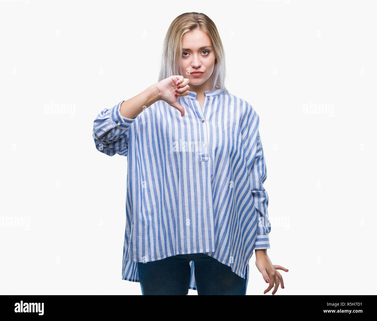 Young blonde woman over isolated background looking unhappy and angry ...