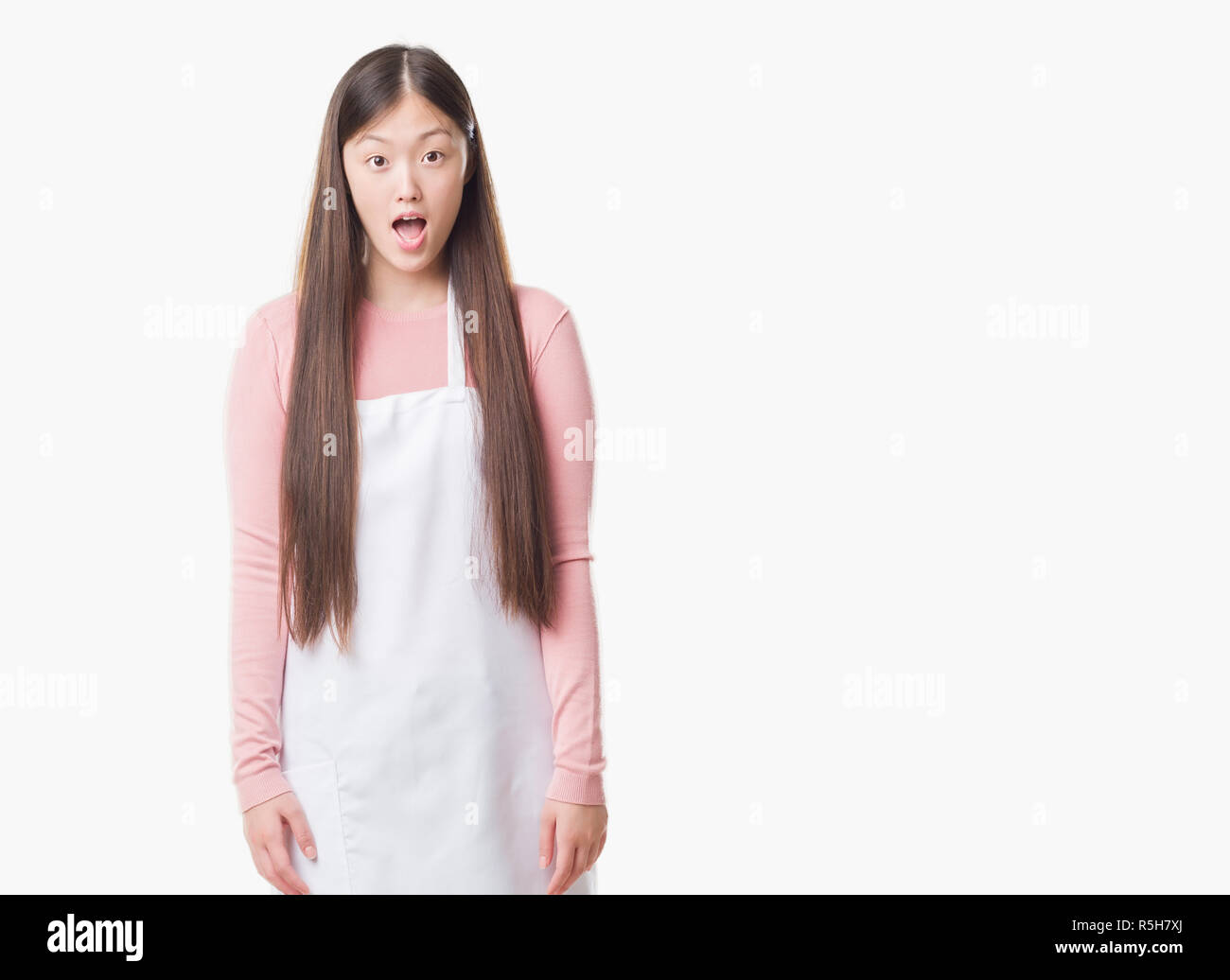 Young Chinese shop owner woman over isolated background wearing white ...
