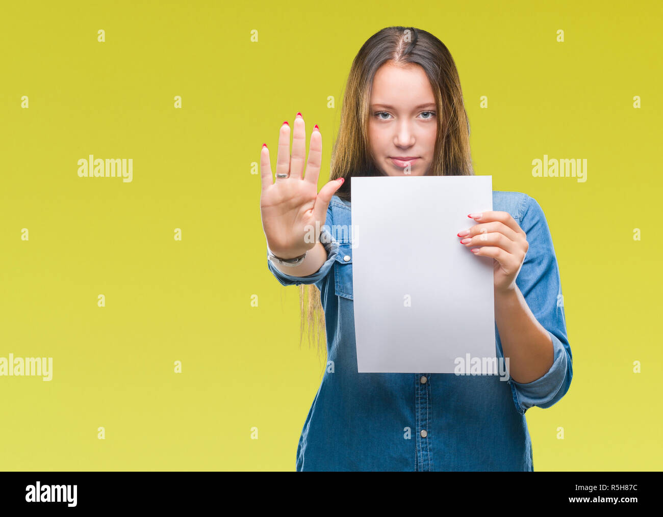 Young caucasian woman holding blank paper sheet over isolated ...