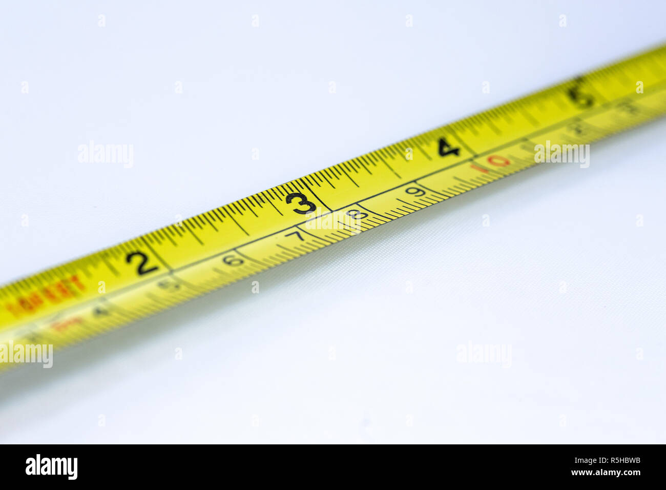 Tape measure closeup with out of focus elements on a white background ...