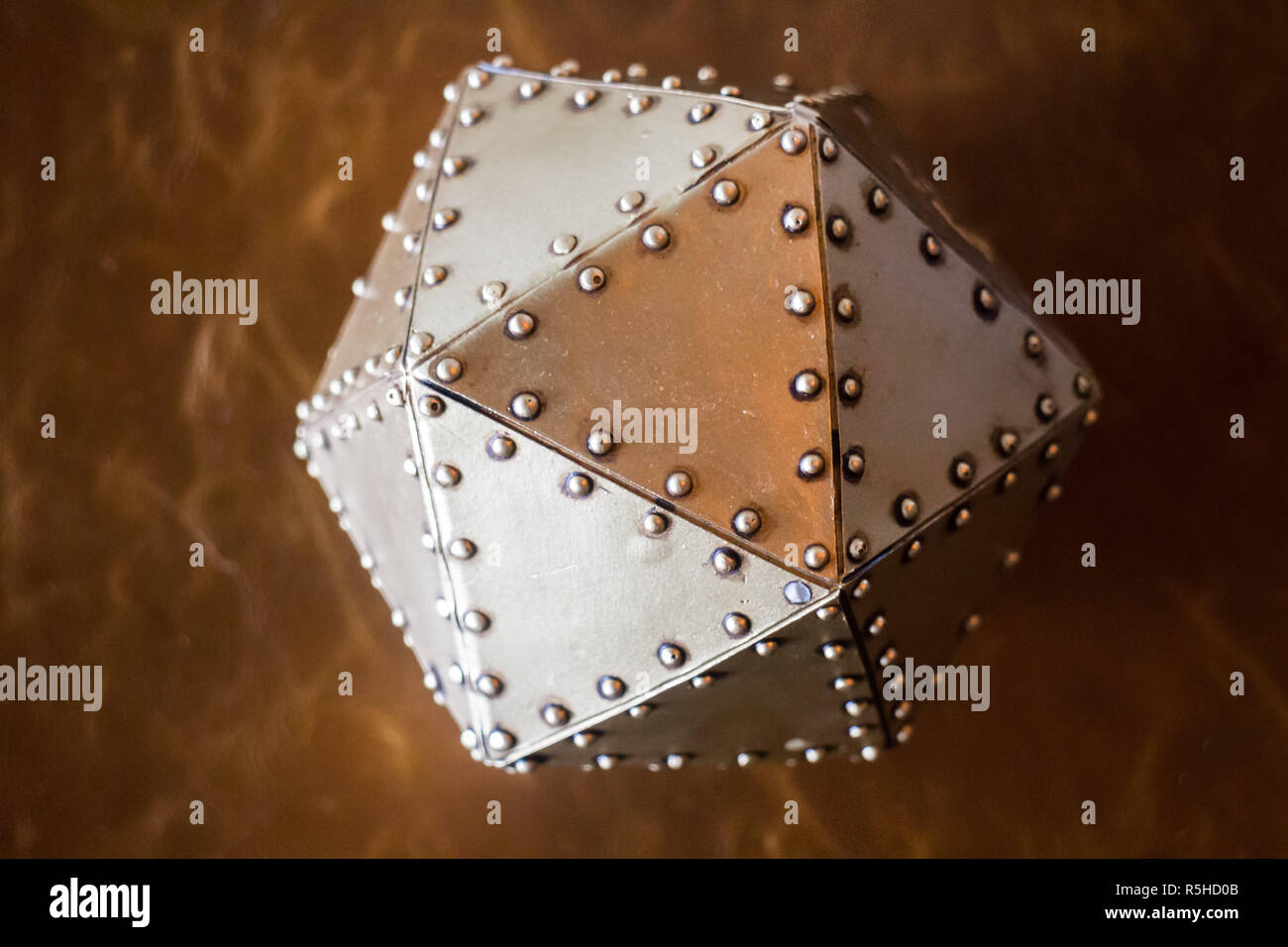 Metal hexagon ball on brown leather background Stock Photo - Alamy