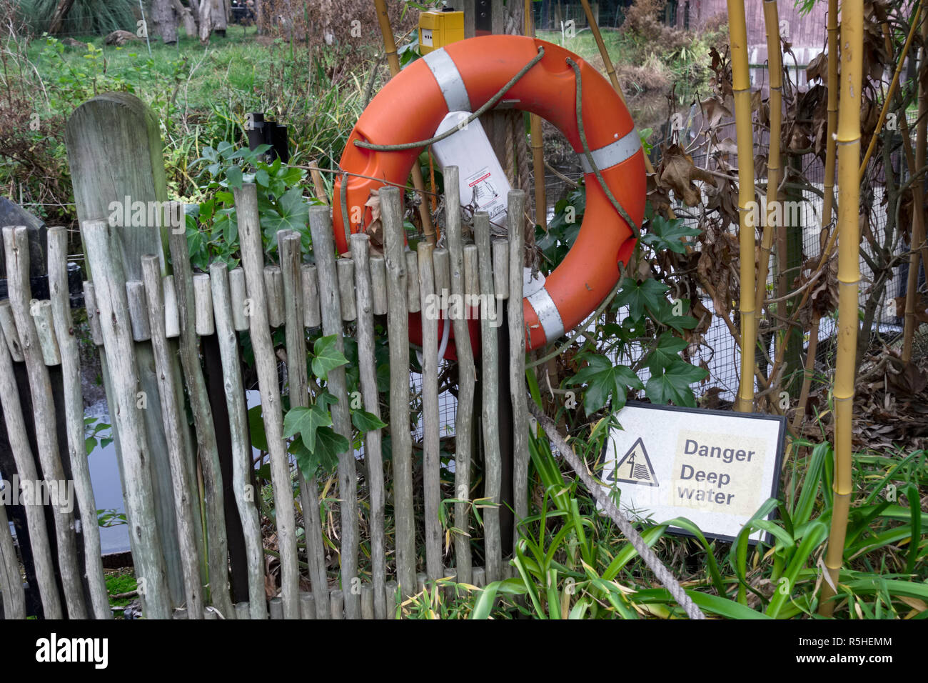 Deep water danger sign and red orange buoy safety ring Stock Photo - Alamy