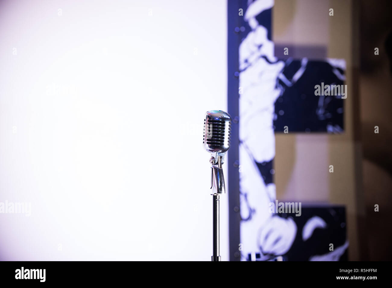 A old style retro microphone standing in the background of white wall ...