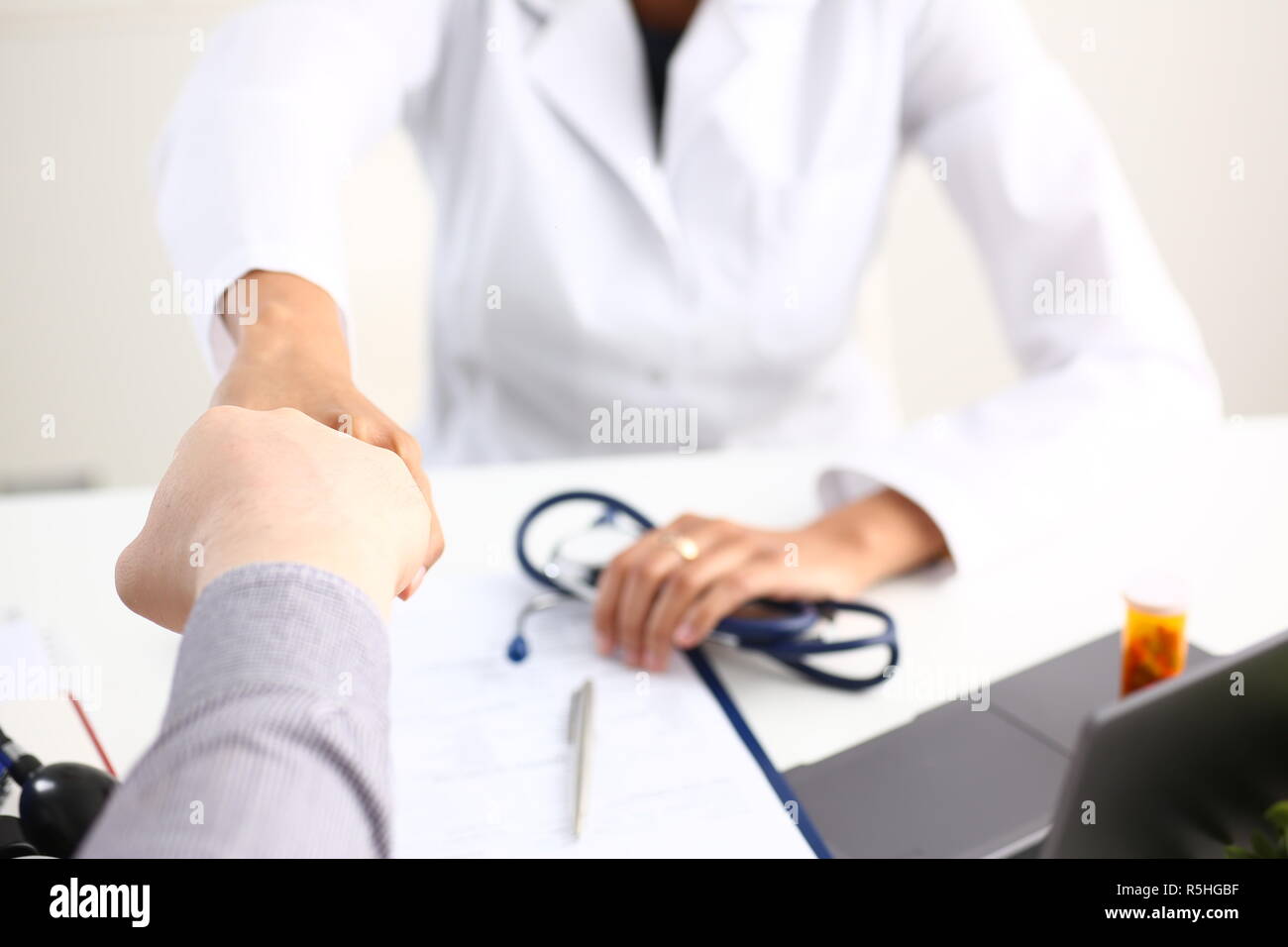 Doctor shake hand as hello with patient Stock Photo - Alamy