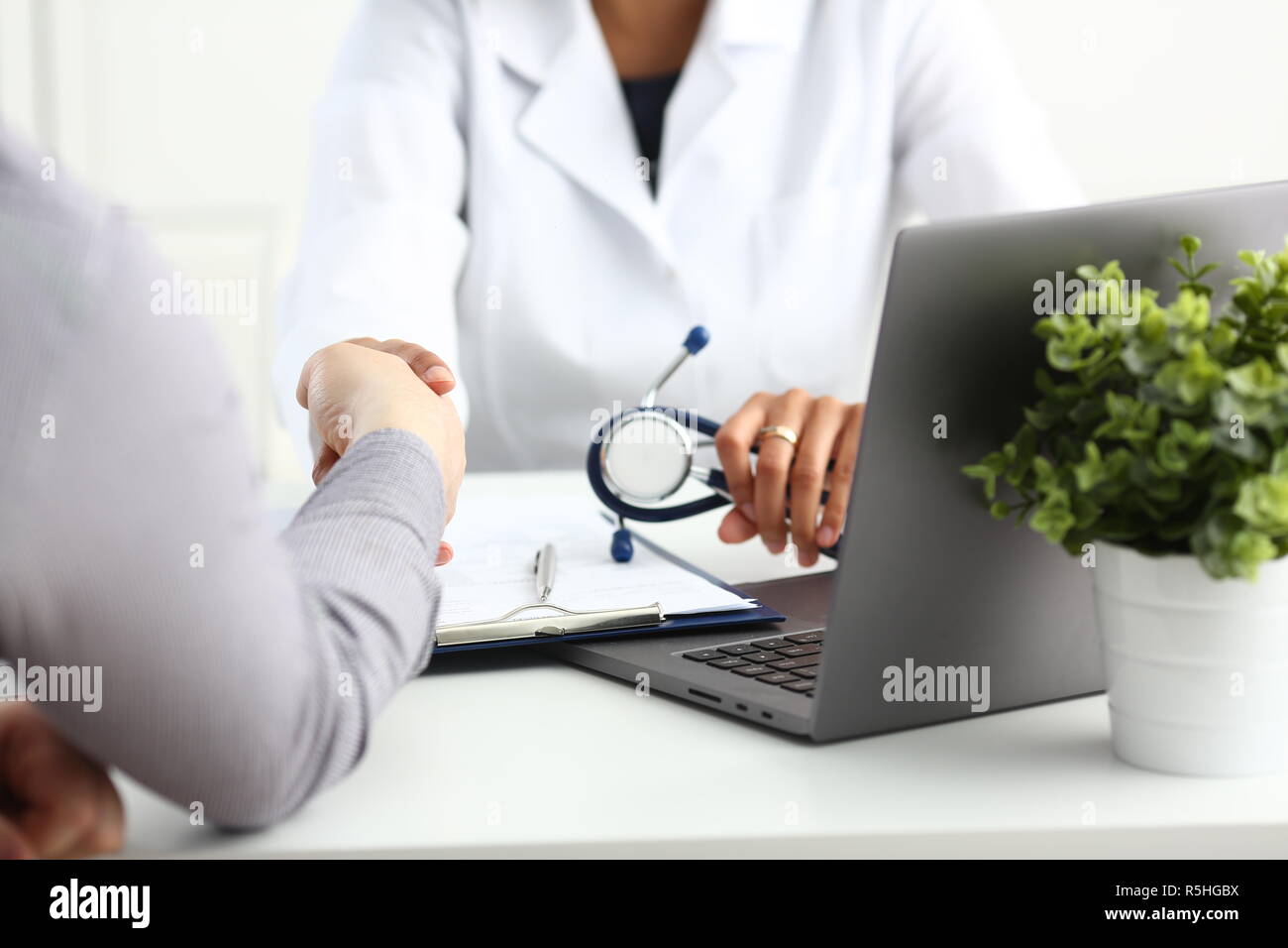 Doctor shake hand as hello with patient Stock Photo - Alamy