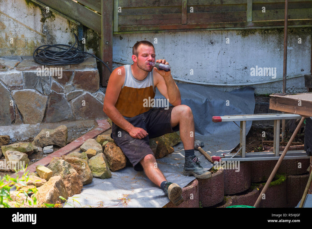 construction worker with refreshment drink in hand Stock Photo - Alamy