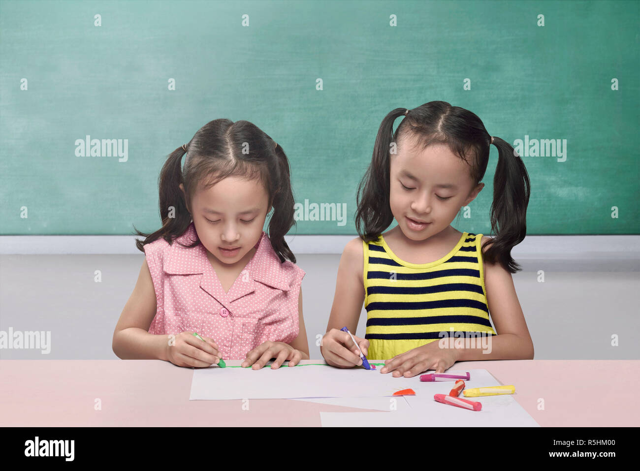 Pretty asian children drawing together on sheet of paper Stock Photo ...