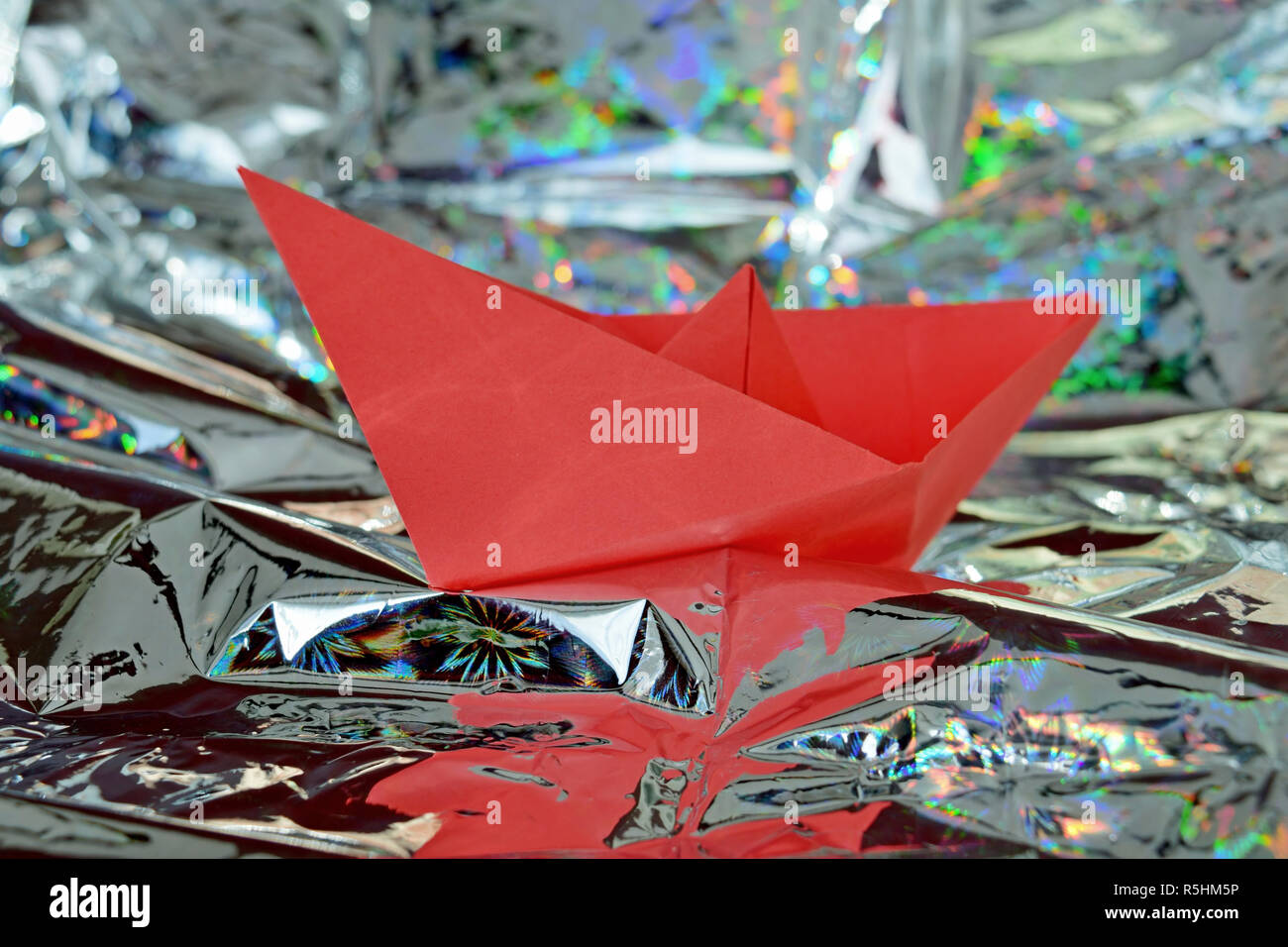red paper boat on foil background Stock Photo - Alamy