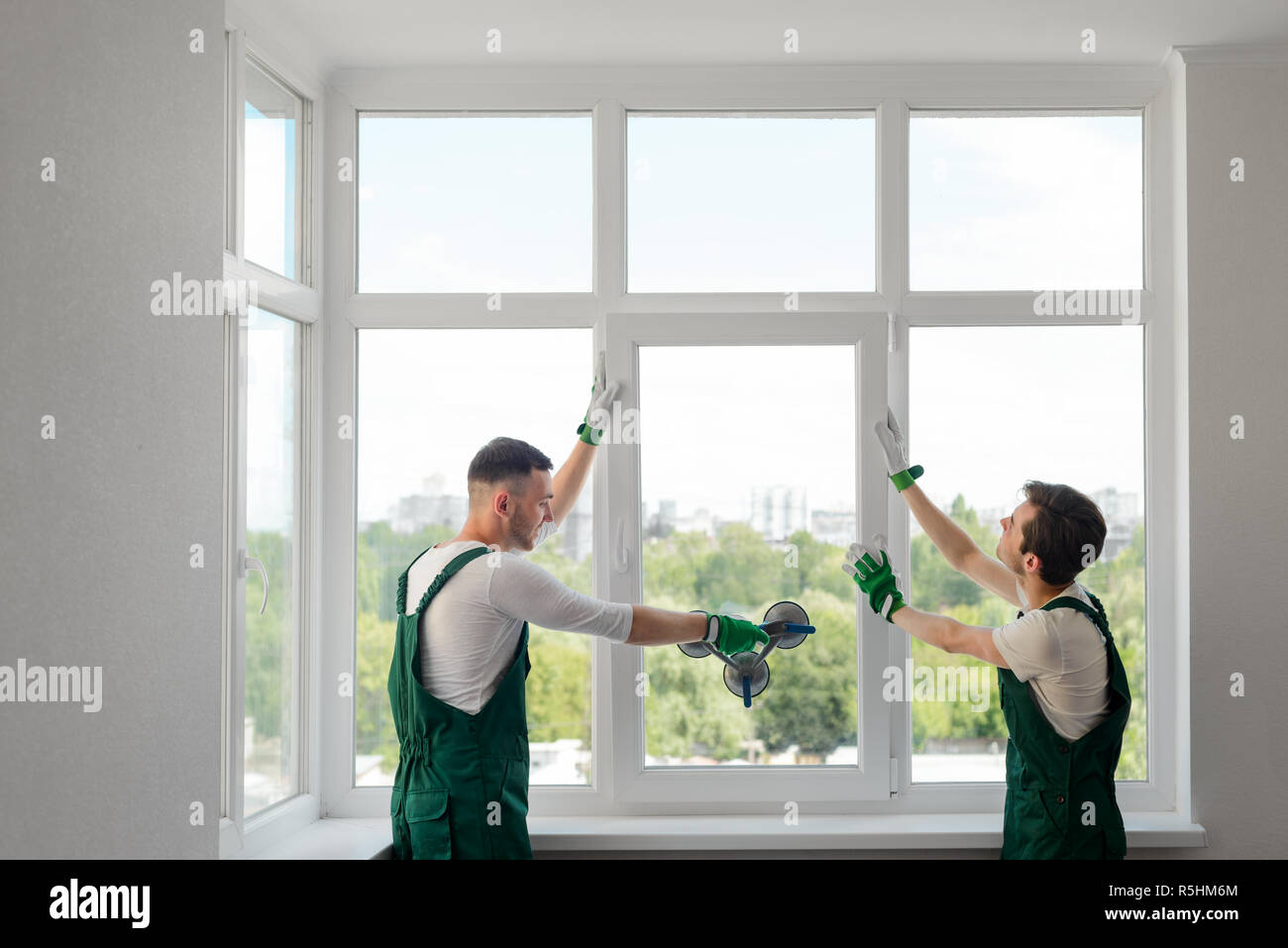 Construction workers install a window Stock Photo - Alamy