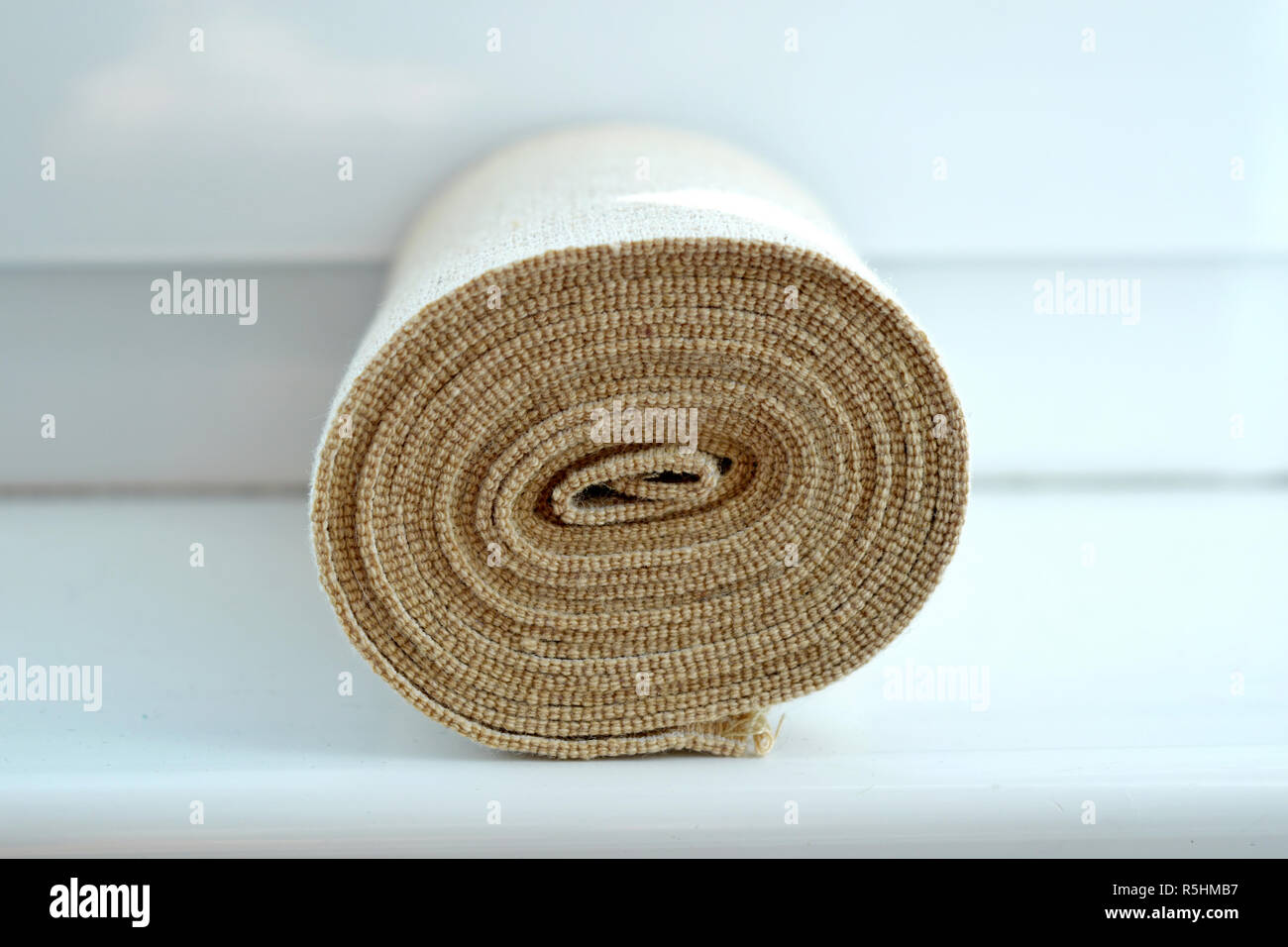 roll of fabric on a light background Stock Photo - Alamy