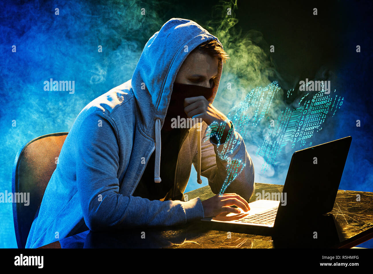 Hooded computer hacker stealing information with laptop Stock Photo - Alamy