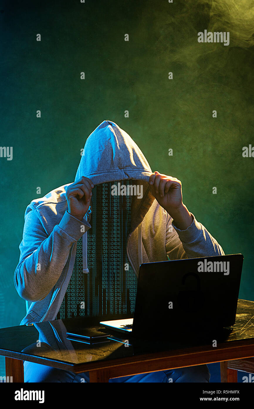 Hooded computer hacker stealing information with laptop Stock Photo - Alamy