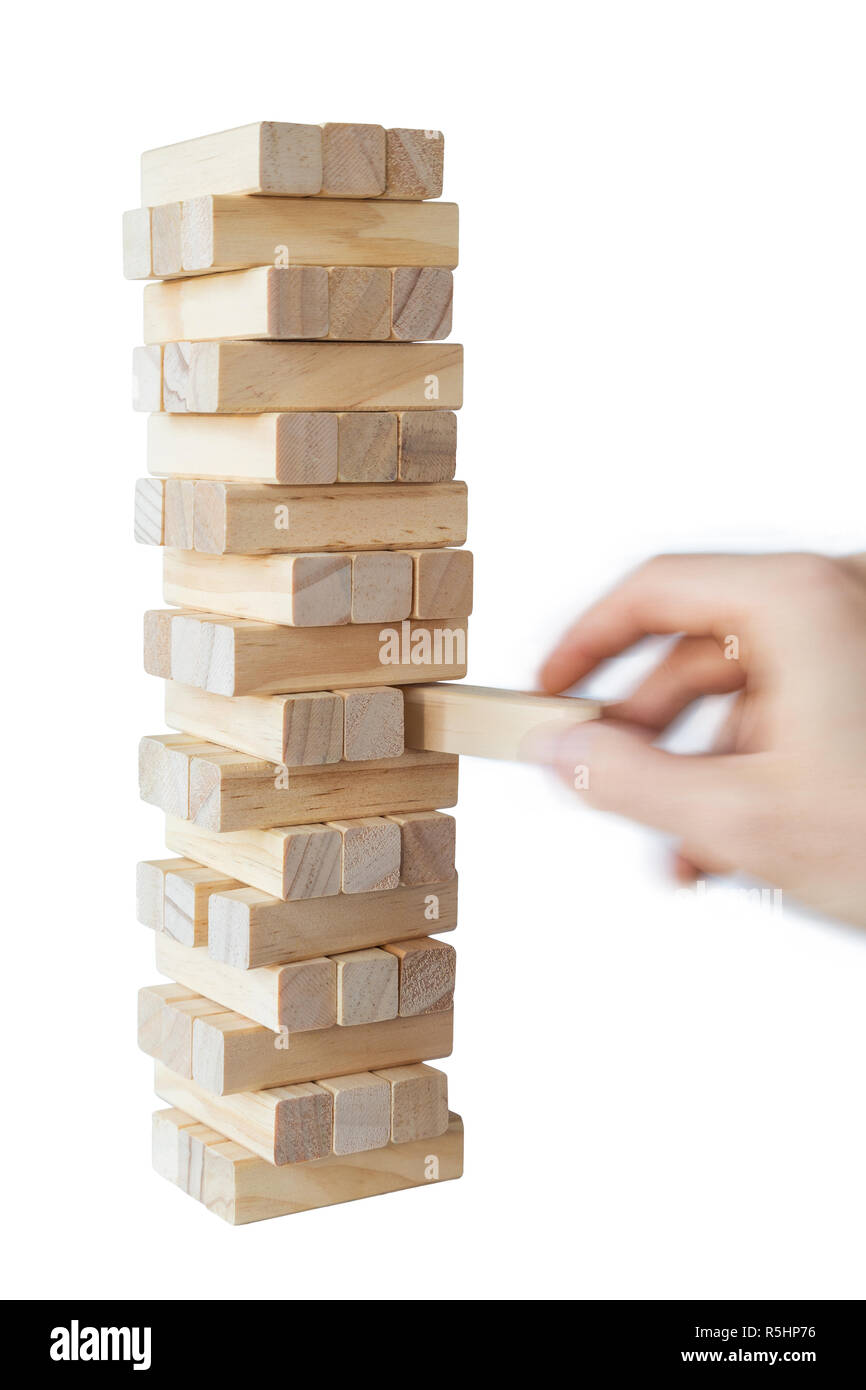 Man's hand taking first block or putting last block to a sturdy tower ...