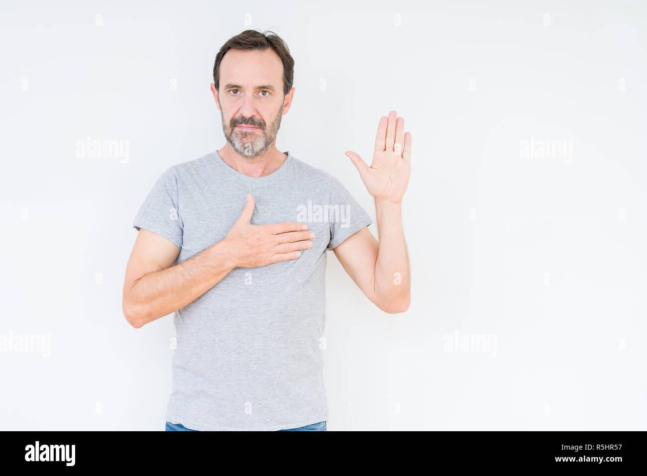 Handsome senior man over isolated background Swearing with hand on ...