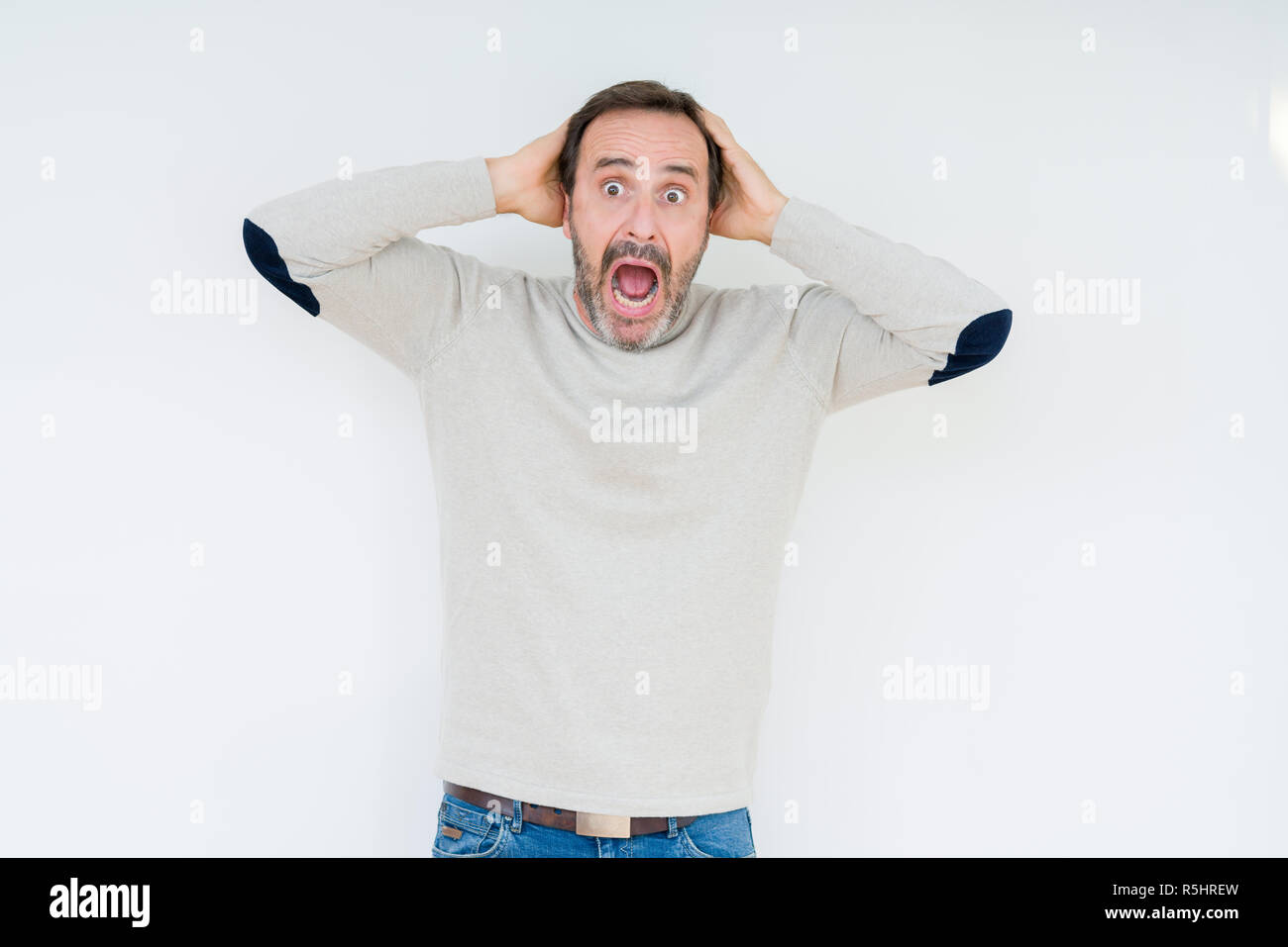 Elegant senior man over isolated background Crazy and scared with hands ...
