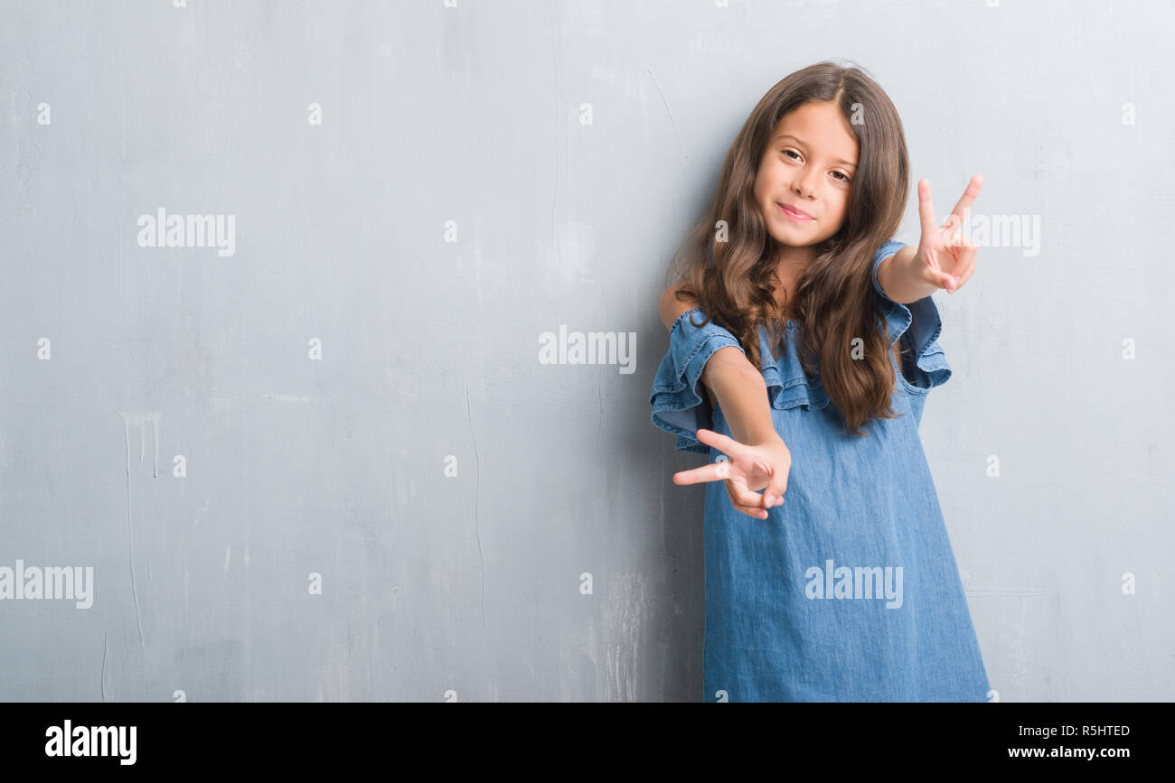 Young hispanic kid over grunge grey wall with sad expression covering ...