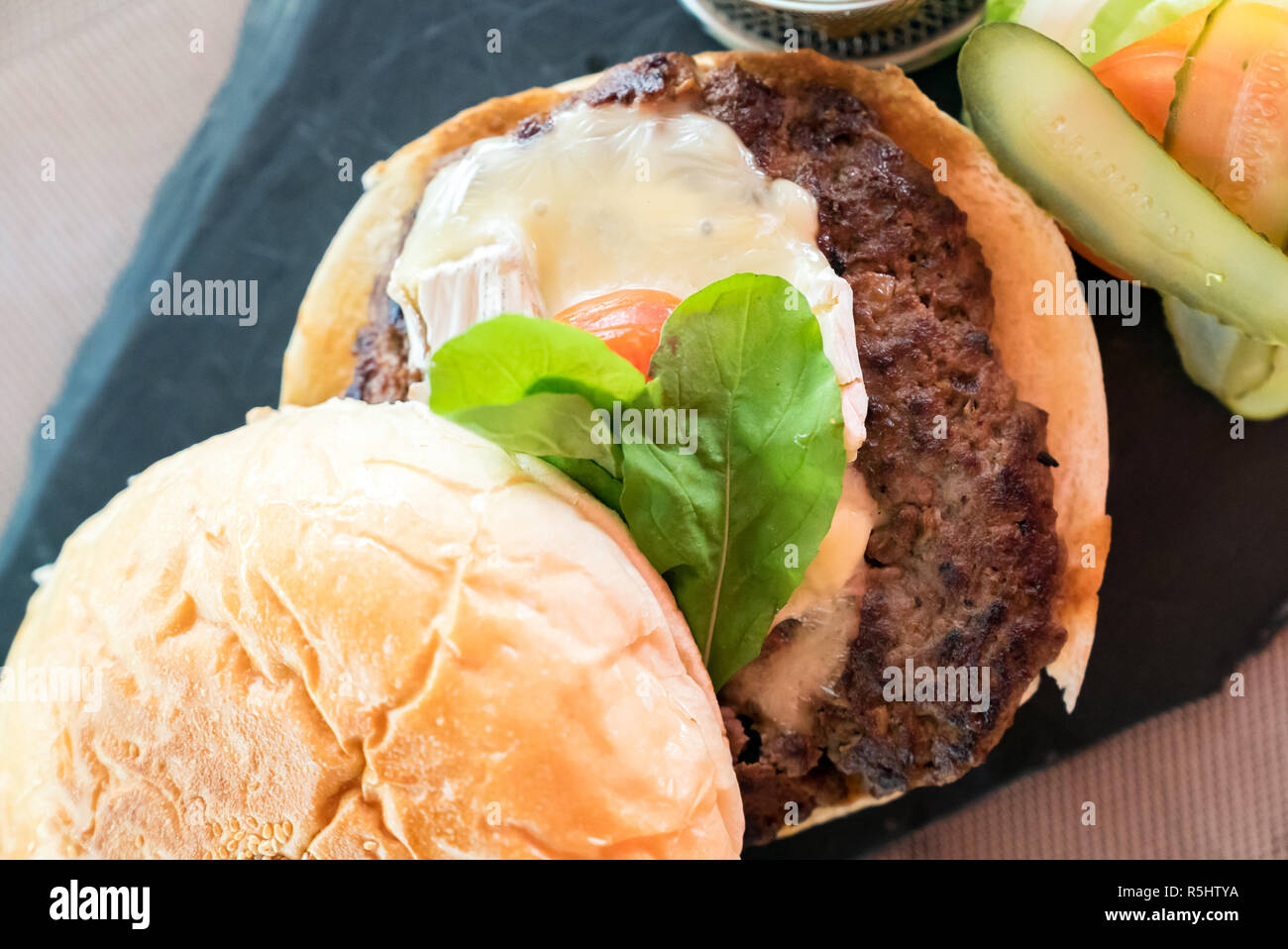 Homemade overload beef hamburger with fresh vegetables and cheese with ...