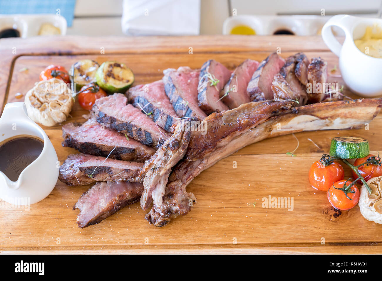 Grilled tomahawk steak on wooden plate Stock Photo - Alamy