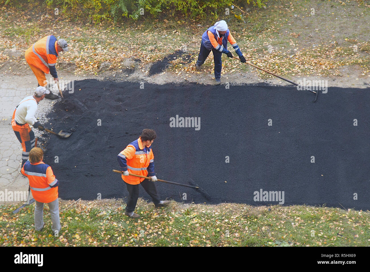 Road street repairing works. Construction workers during asphalting ...