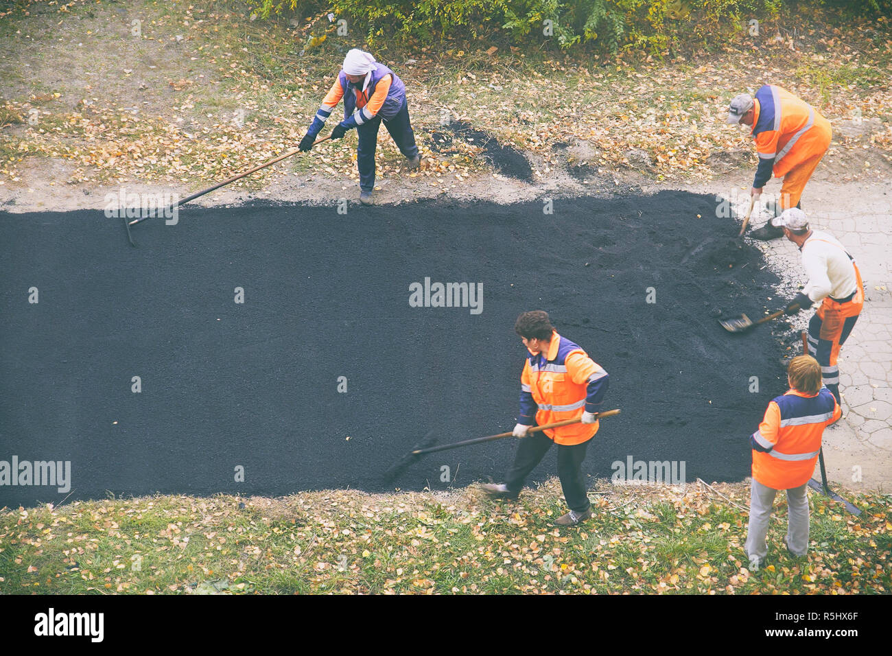 Road street repairing works. Construction workers during asphalting ...