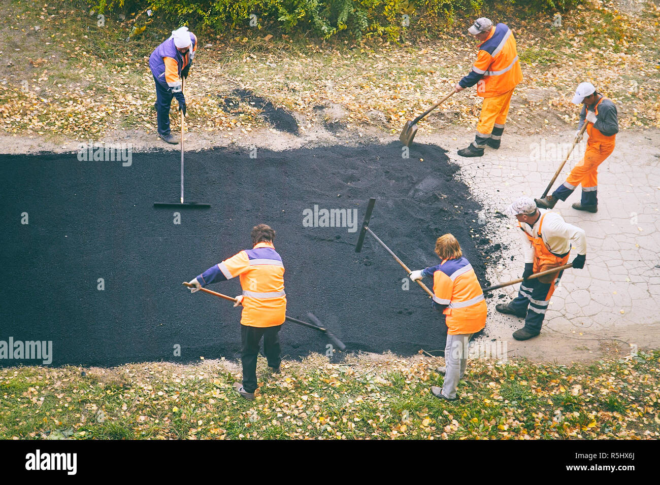 Road street repairing works. Construction workers during asphalting ...