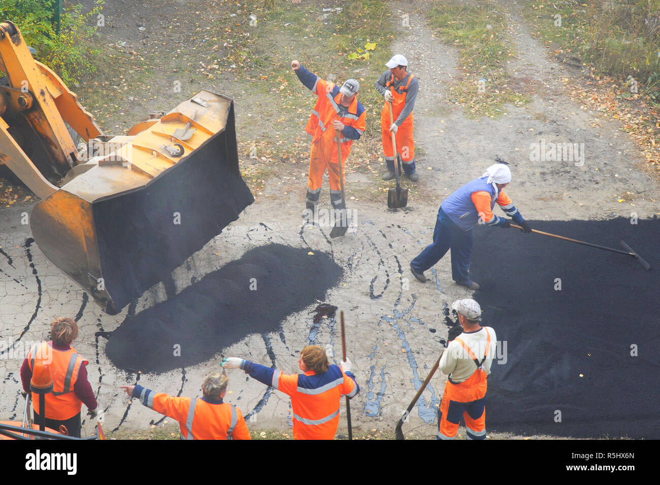 Road street repairing works. Construction workers during asphalting ...