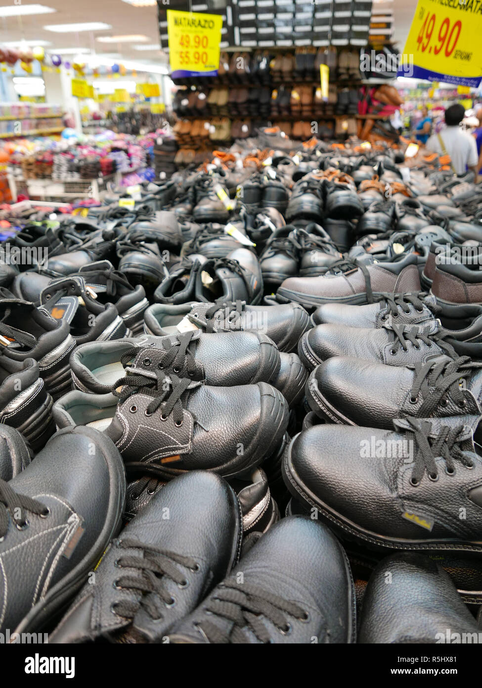 A stack of casual shoes piled in supermarket. Close up Stock Photo - Alamy