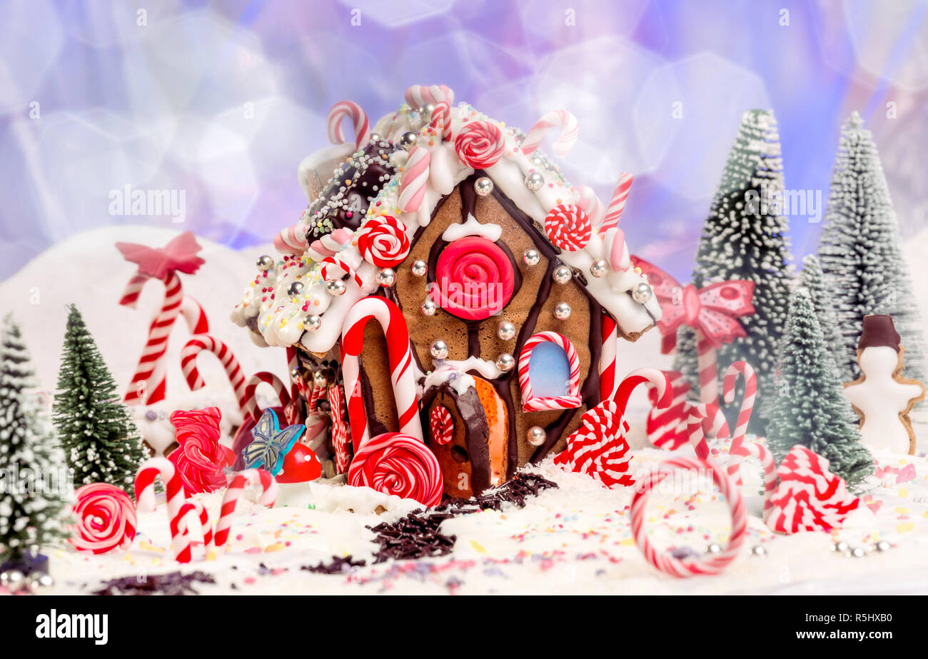 gingerbread house in a fairytale winter landscape with red candy canes ...